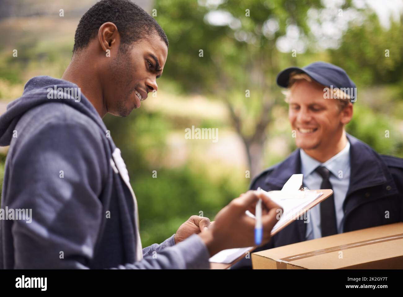 Making sense of the forms. a handsome young man signing a form for a ...