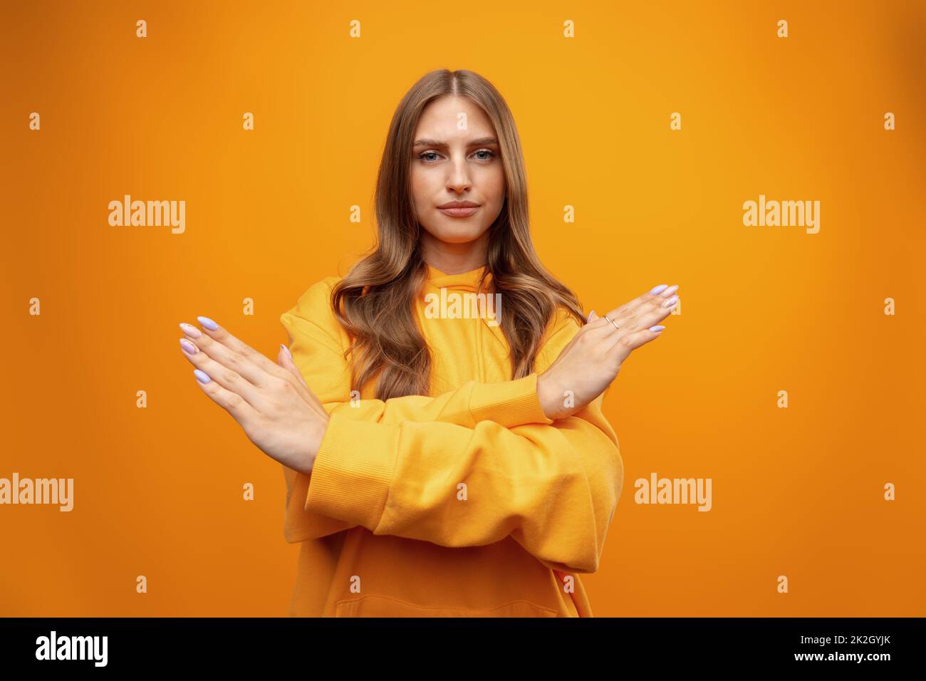 Portrait of attractive girl showing reject sign with crossed arms in ...