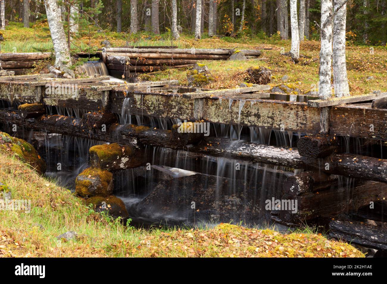 A water power construction of wooden logs. Water leak, seeps through ...