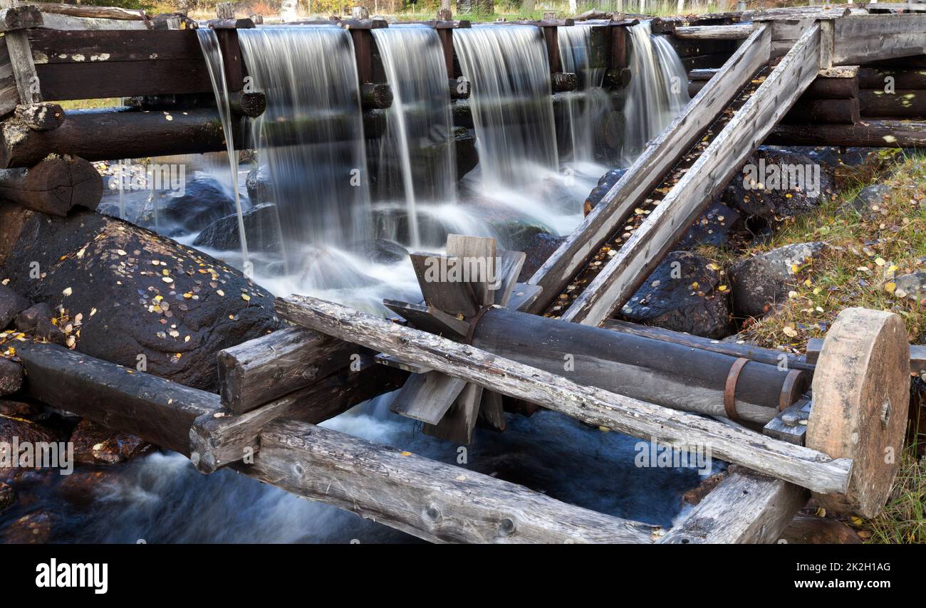 A water power construction of wooden logs. Water leak, seeps through ...