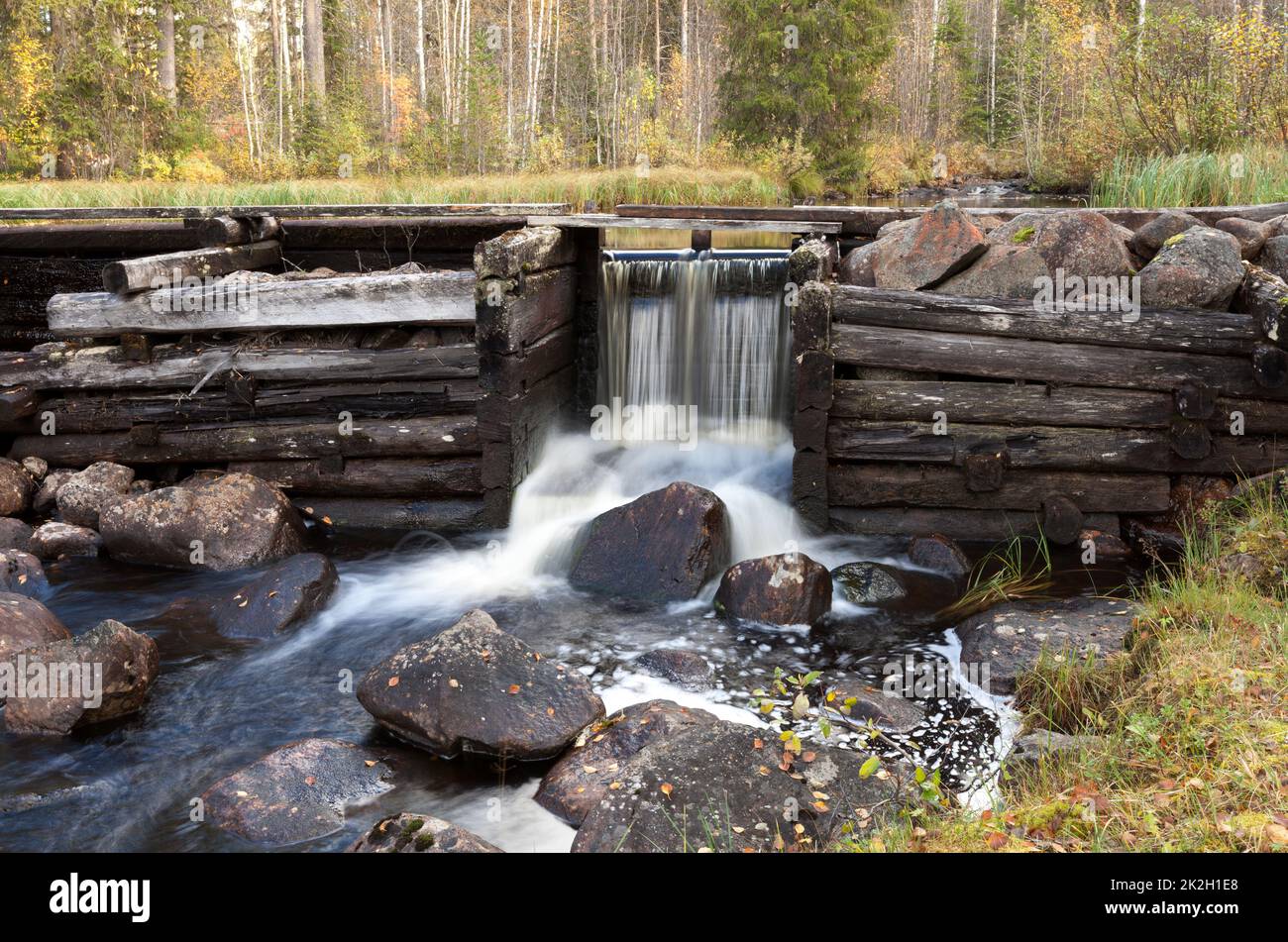 A water power construction of wooden logs. Water leak, seeps through ...