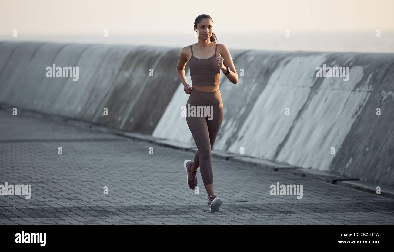 Fresh air runs are the most energising. Shot of a sporty young woman ...