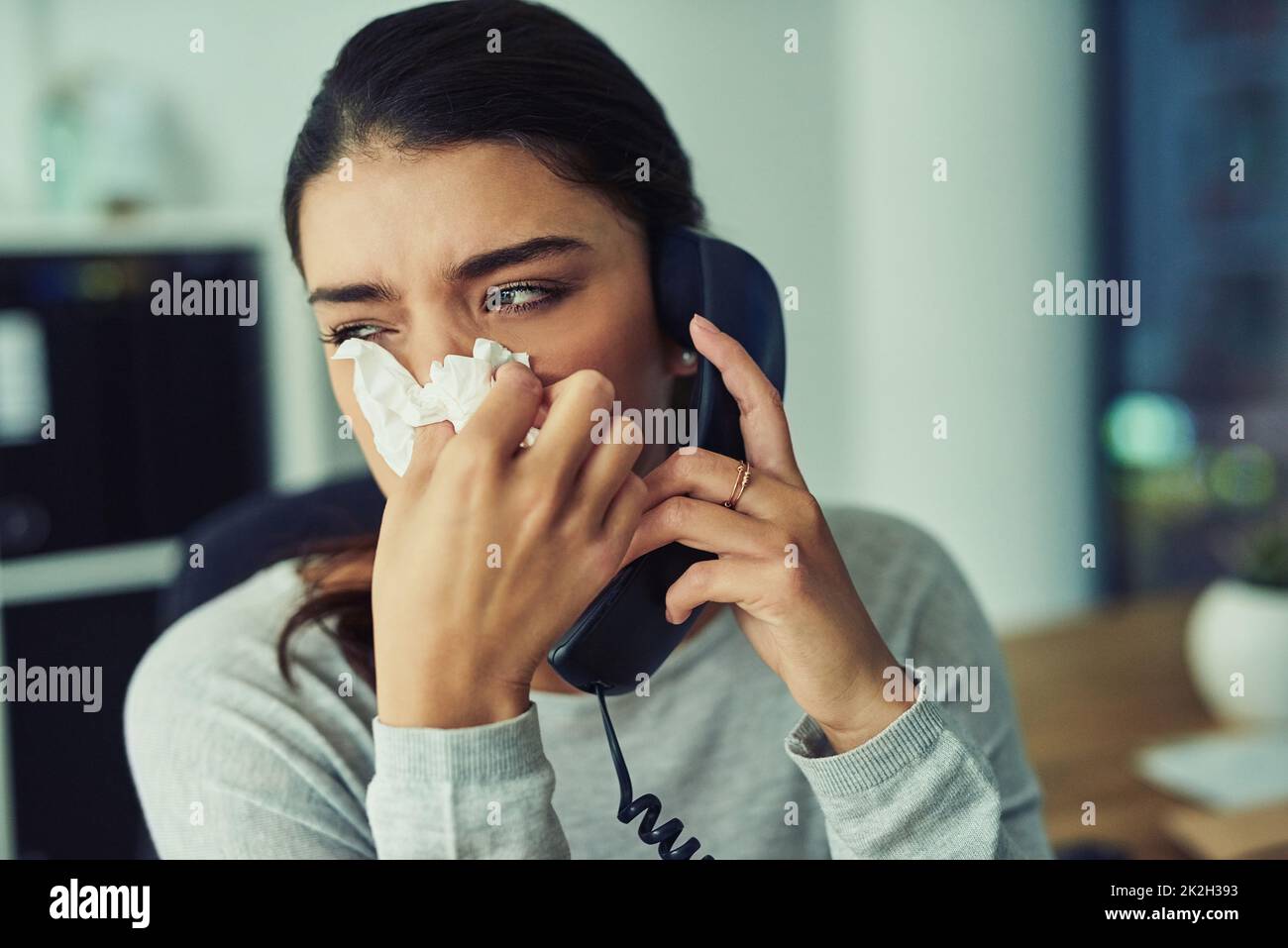 Time to call up the doctor. Shot of a young businesswoman blowing her ...