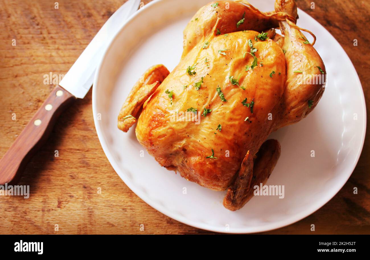 Whole roasted chicken on white plate Stock Photo - Alamy