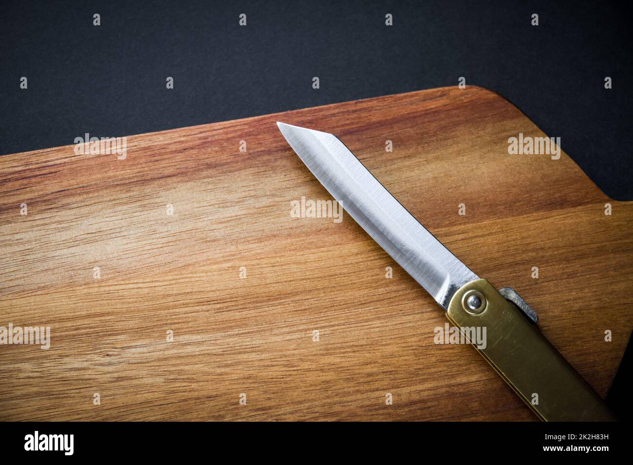 Traditional japanese pocket knife on a wooden cutting board Stock Photo ...