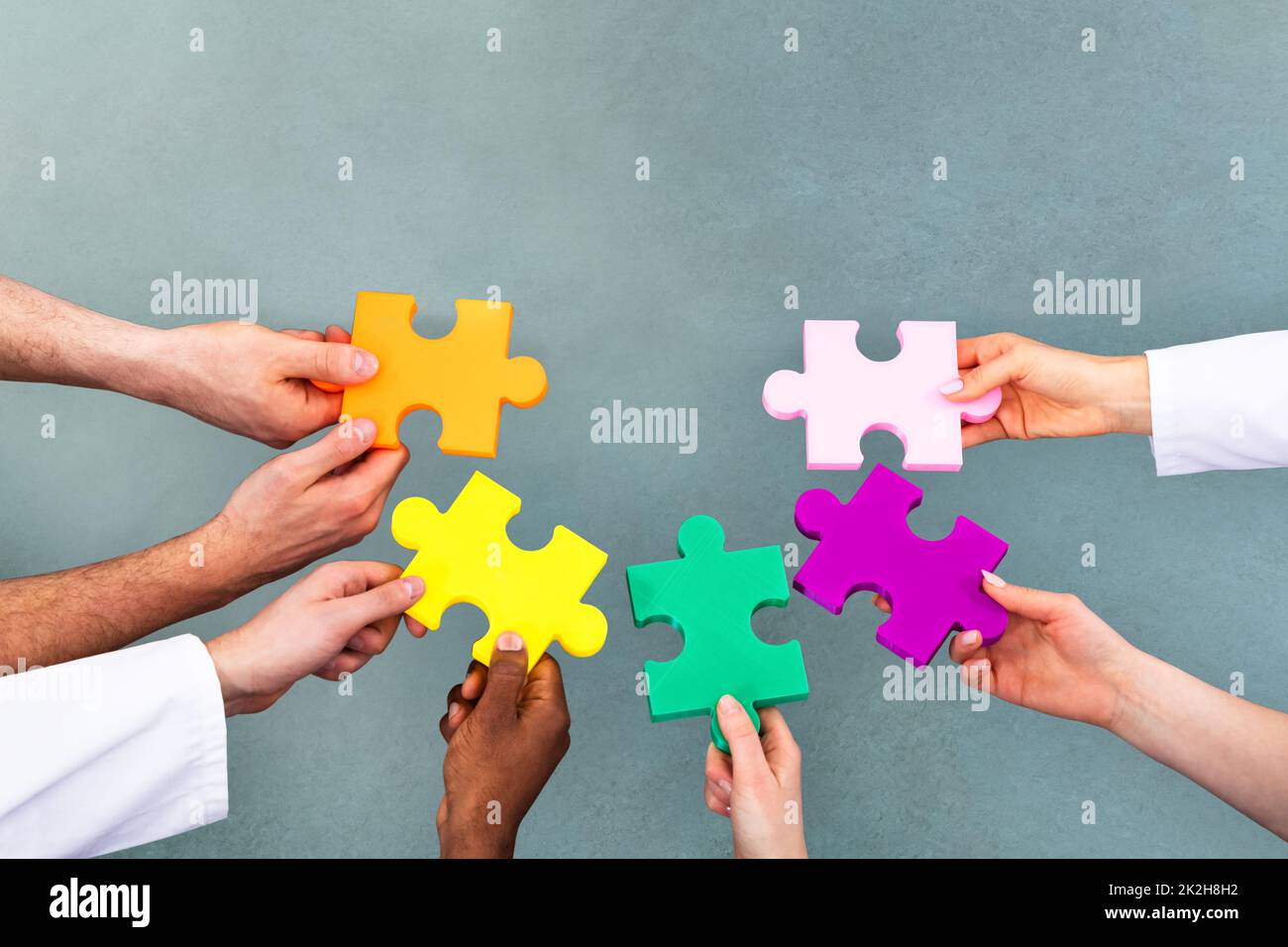 High Angle View Of Medical Team Solving Jigsaw Puzzle Stock Photo - Alamy