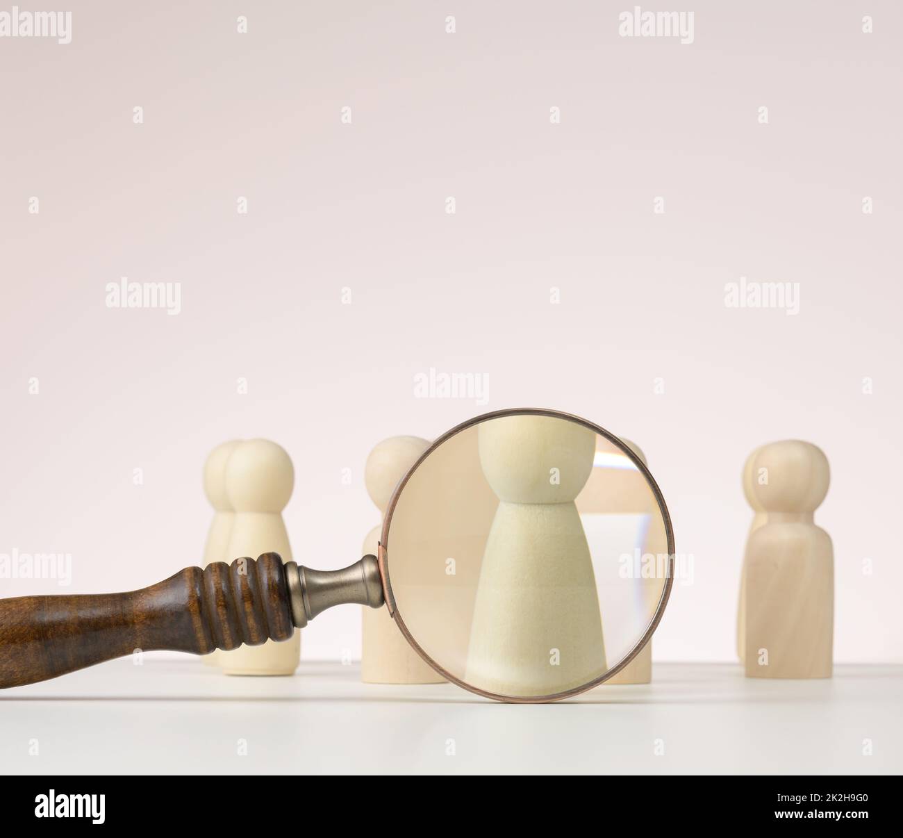figurines of men on a white table and magnifying glass. Concept of ...