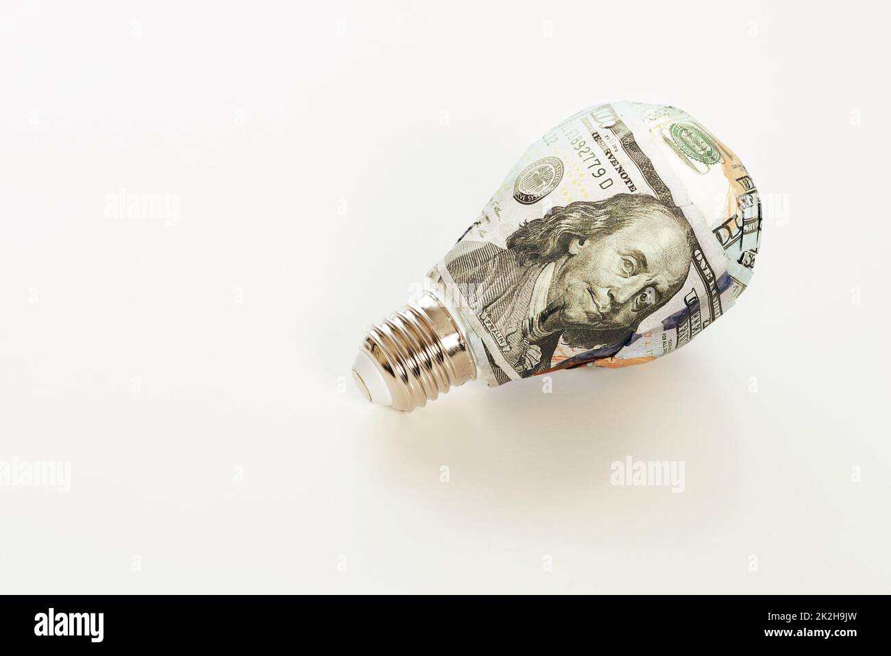 100 dollar banknote wrapped light bulb on a white background Stock ...