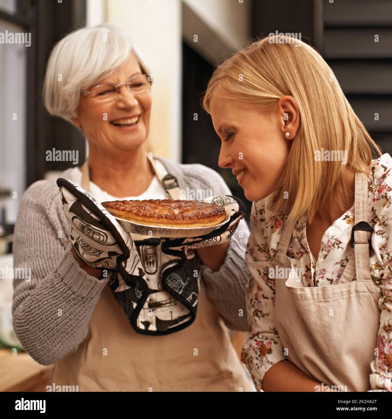 Smells like home. a young woman smelling the baked pie her grandmother ...