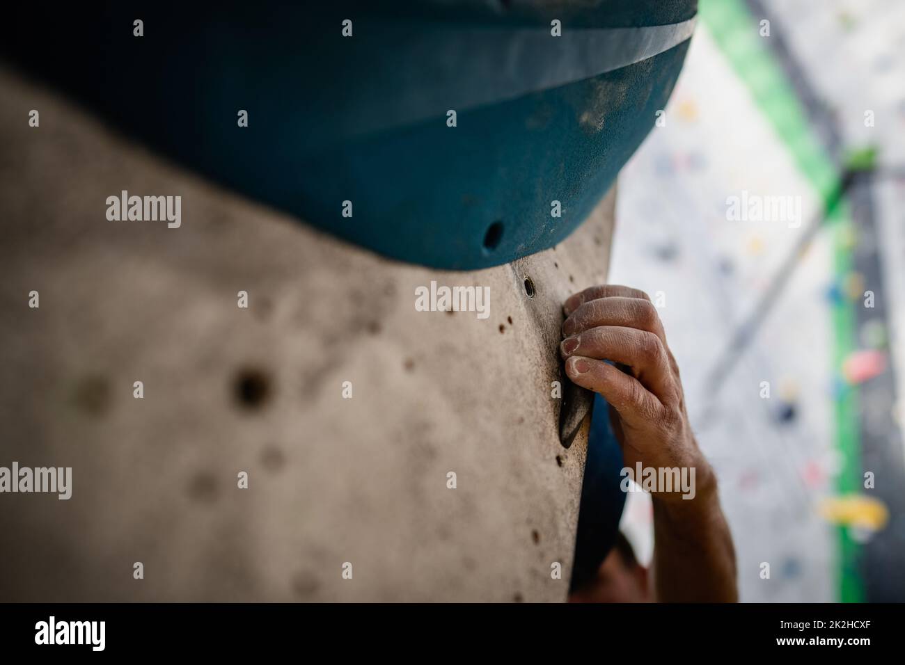 Male hand smeared with magnesium powder grabbing a hold of a climbing ...