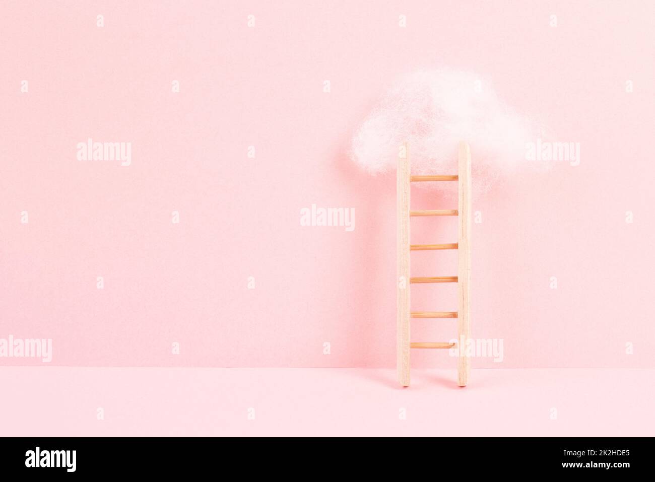 Ladder with a cloud on top, pink rose colored background, copy space ...