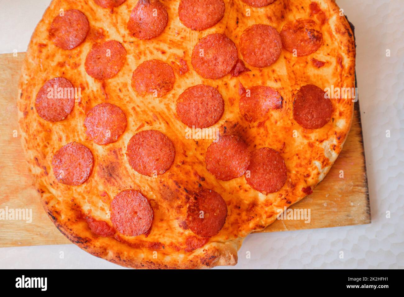Round pizza background - macro photography of pepperoni pizza on a ...