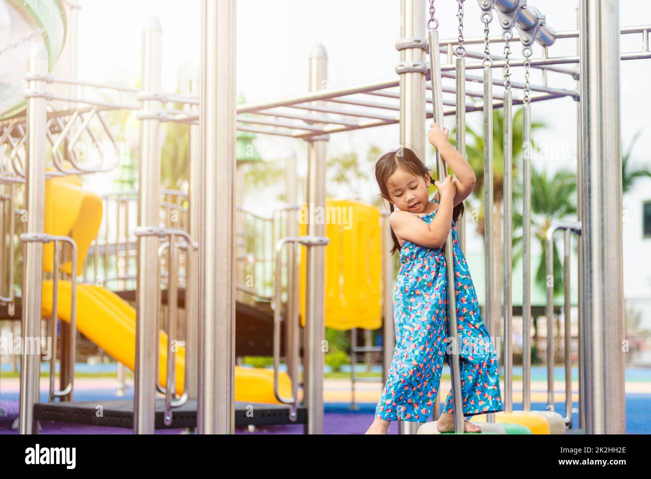 child playing on outdoor playground, happy preschool little kid having funny while playing on ...