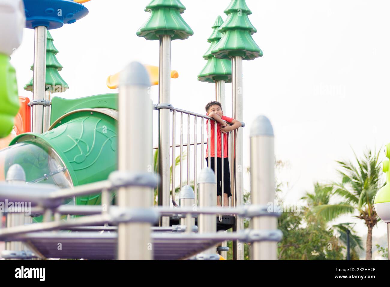 child playing on outdoor playground, happy preschool little kid having funny while playing on ...