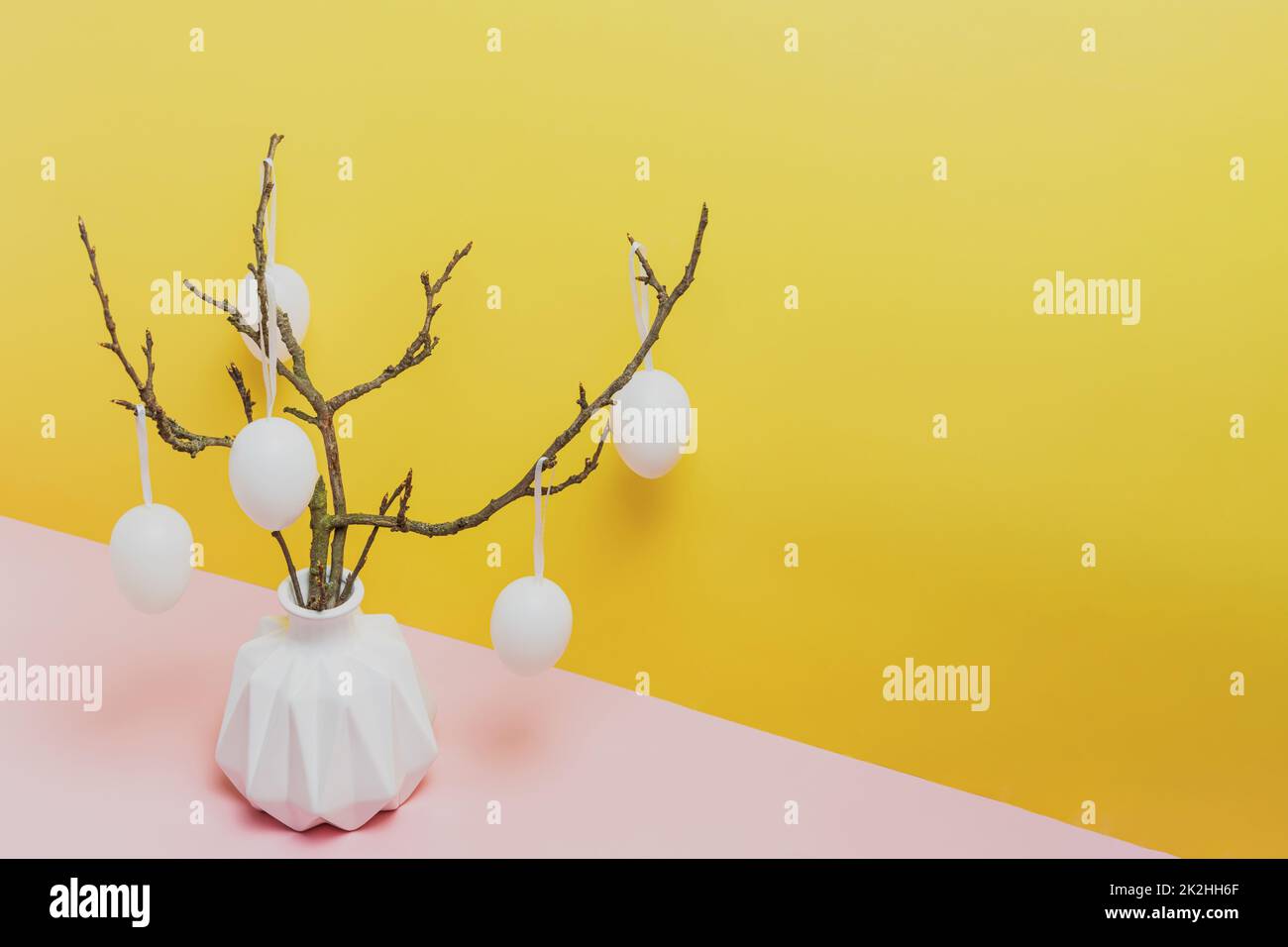 Happy Easter holiday, coming spring. Branches in white vase, hanging ...