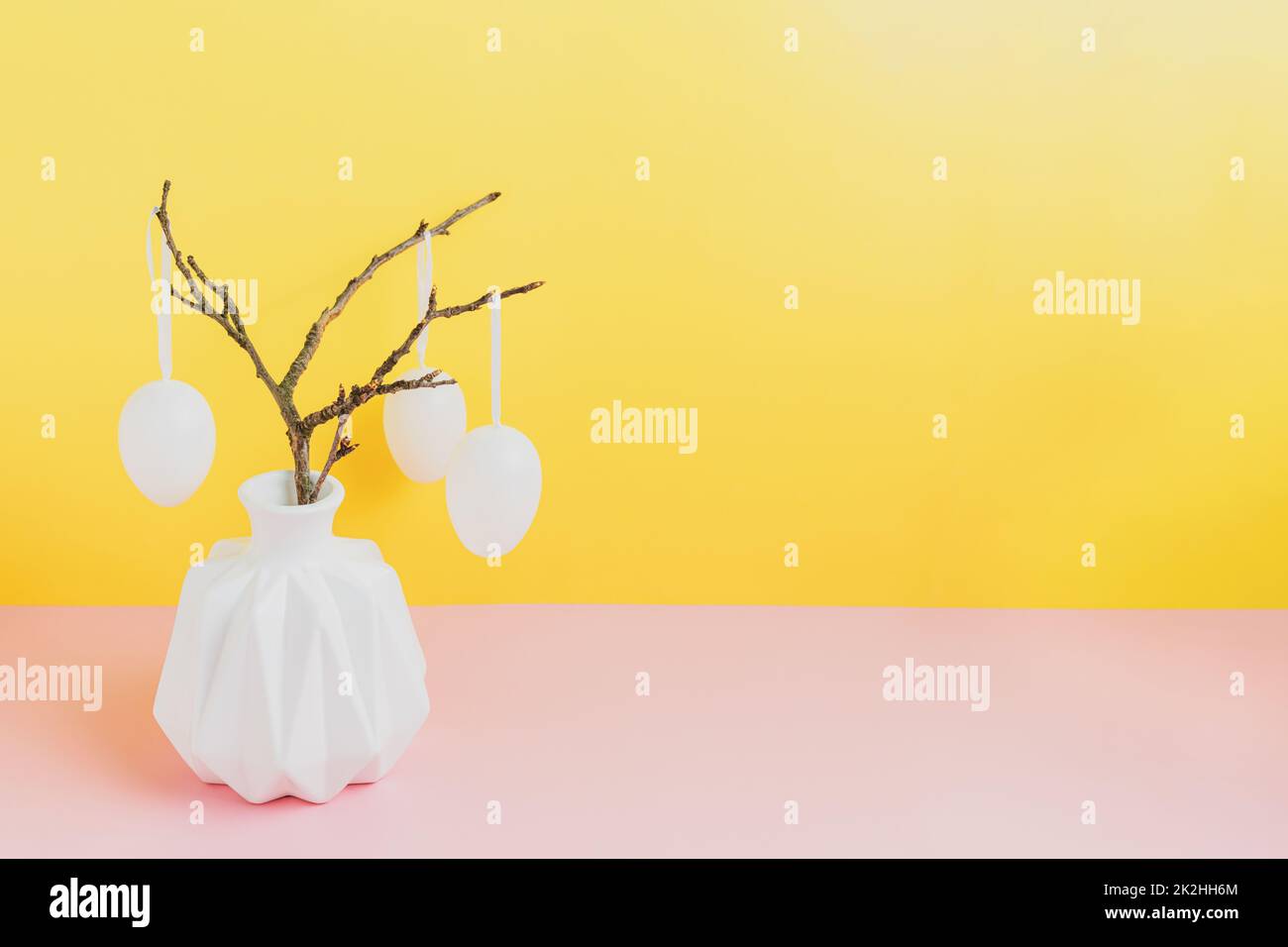 Happy Easter holiday, coming spring. Branches in white vase, hanging ...