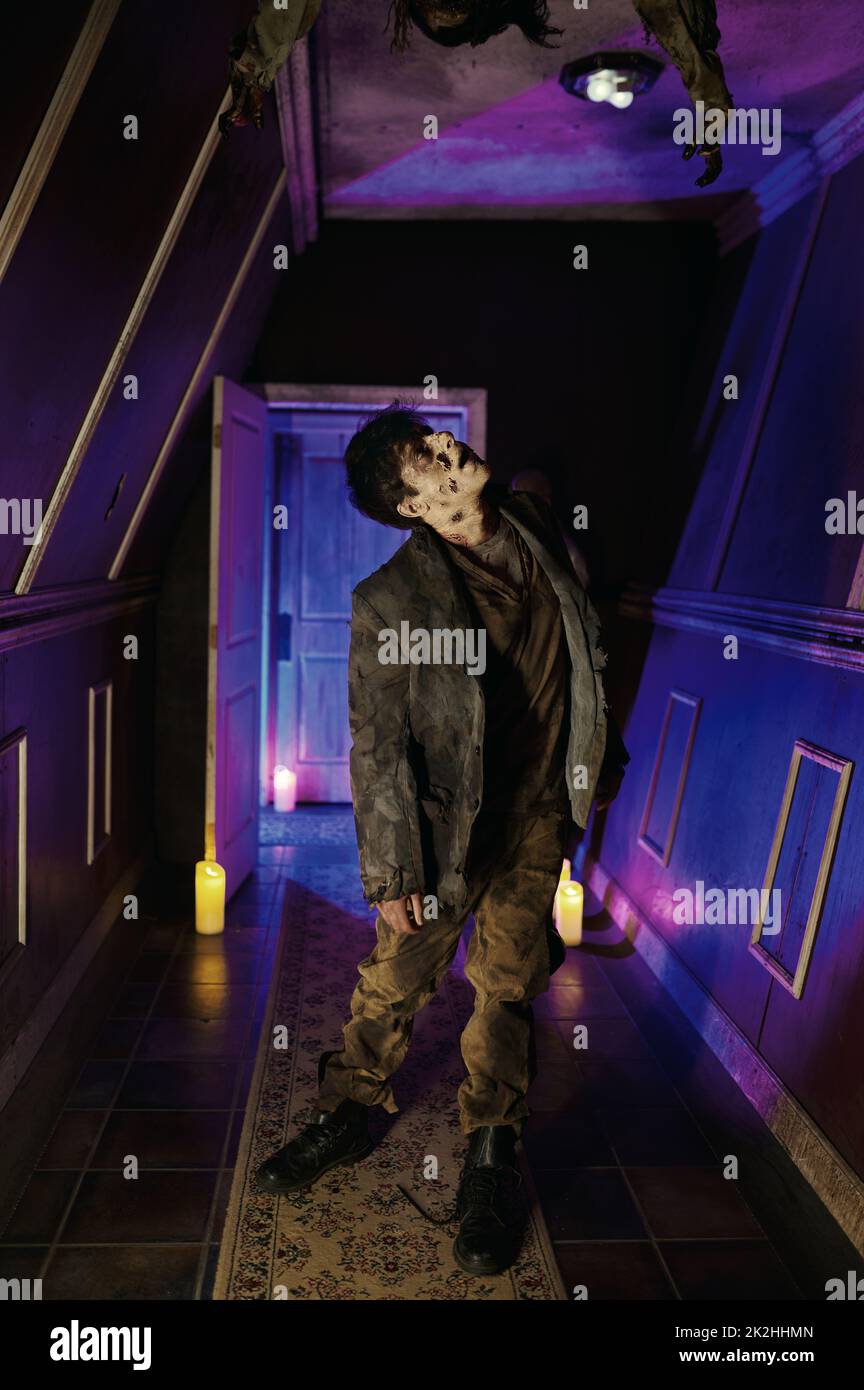 Zombie in neon illuminated horror house hall Stock Photo - Alamy