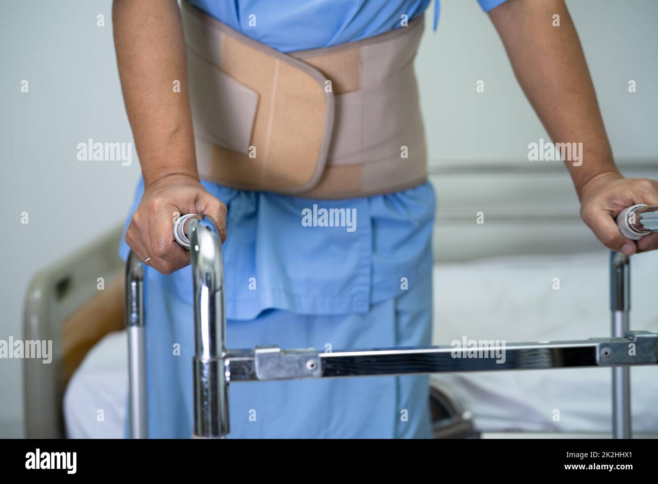 Asian lady patient wearing back pain support belt for orthopedic lumbar ...