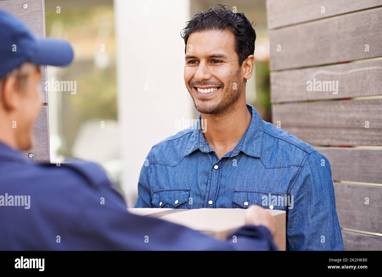Delivery with a smile. A friendly delivery man delivering a package to ... Delivery with a smile. A friendly delivery man delivering a package to ...
