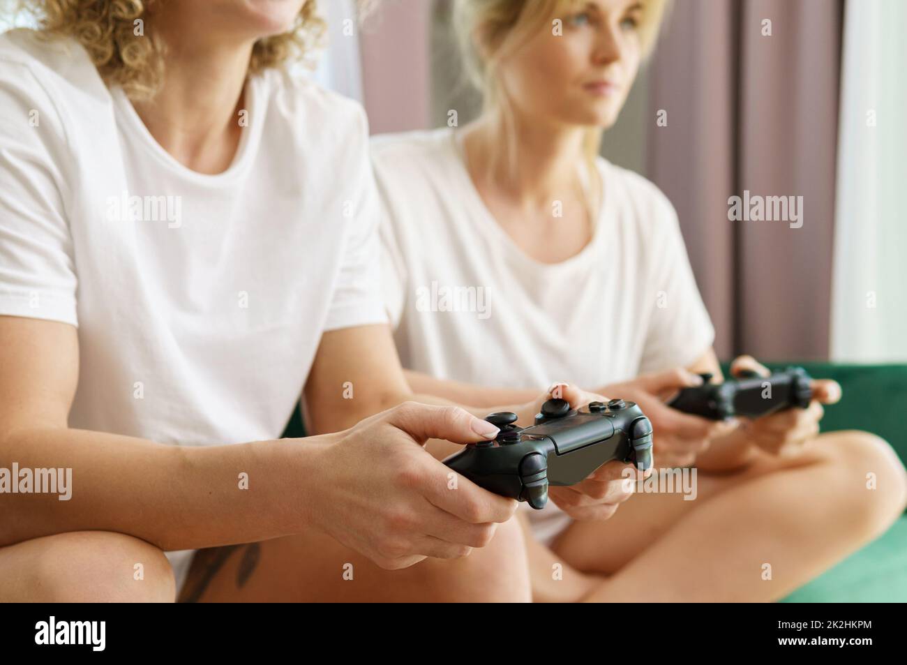 Two girls playing video game console in living room Stock Photo - Alamy