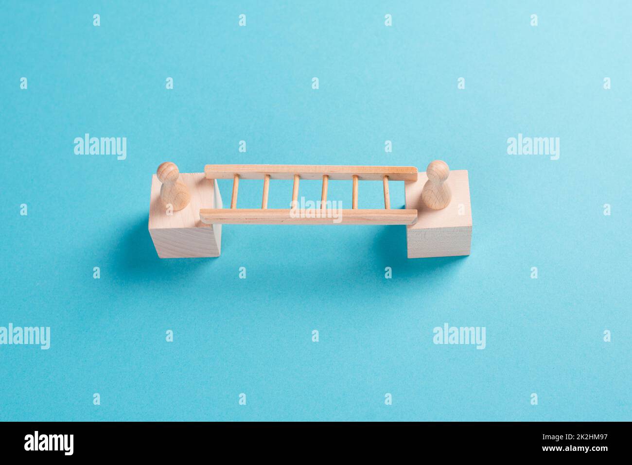 Two people connect by a ladder, buliding a bridge between men ...