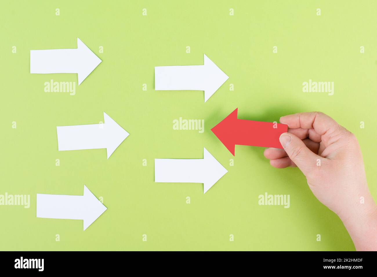 White arrows on a green background, one red is standing out, do ...