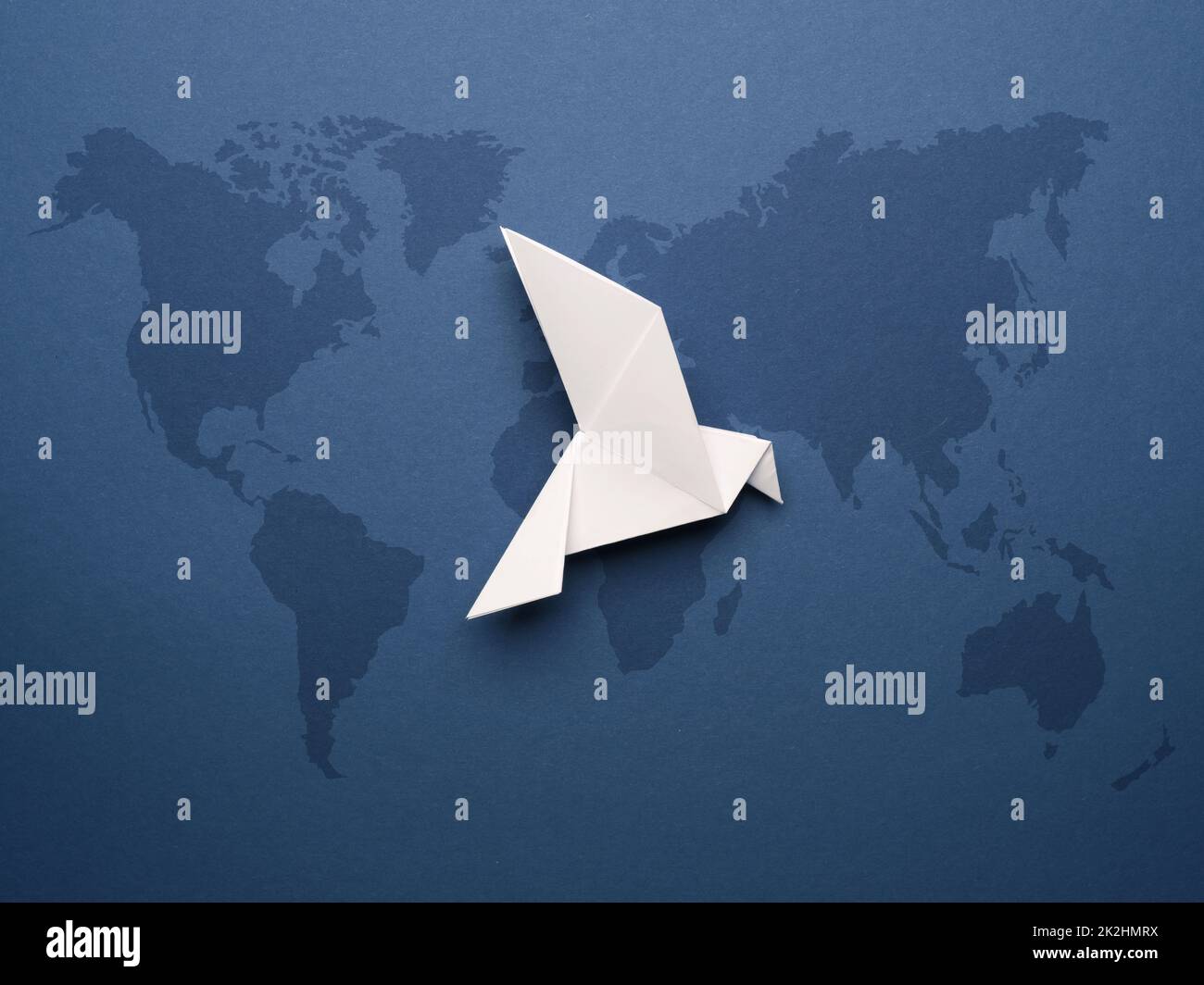 White origami pigeon on a blue paper background Stock Photo - Alamy