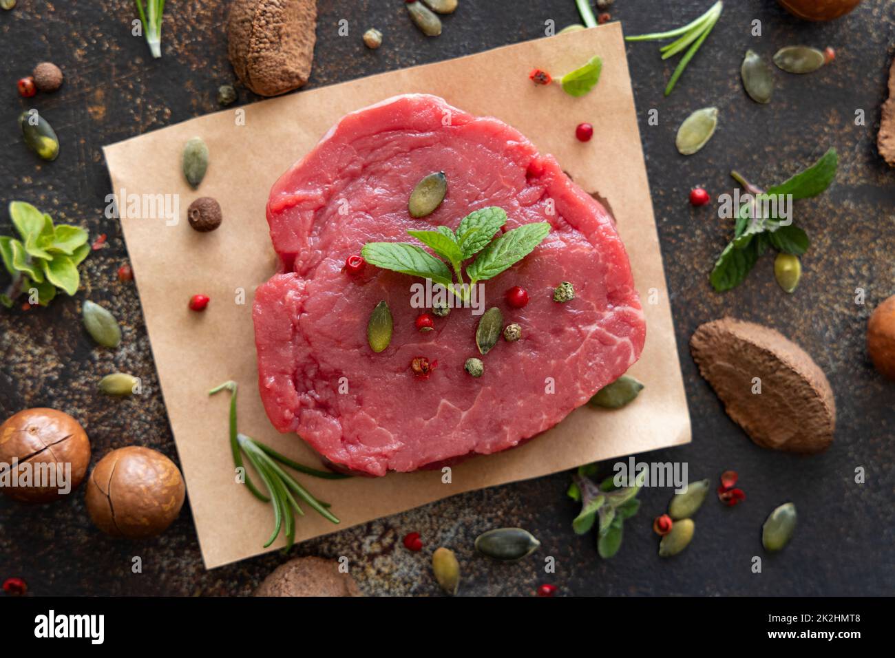 Raw beef fillet steak with herbs and spices on dark table top view ...