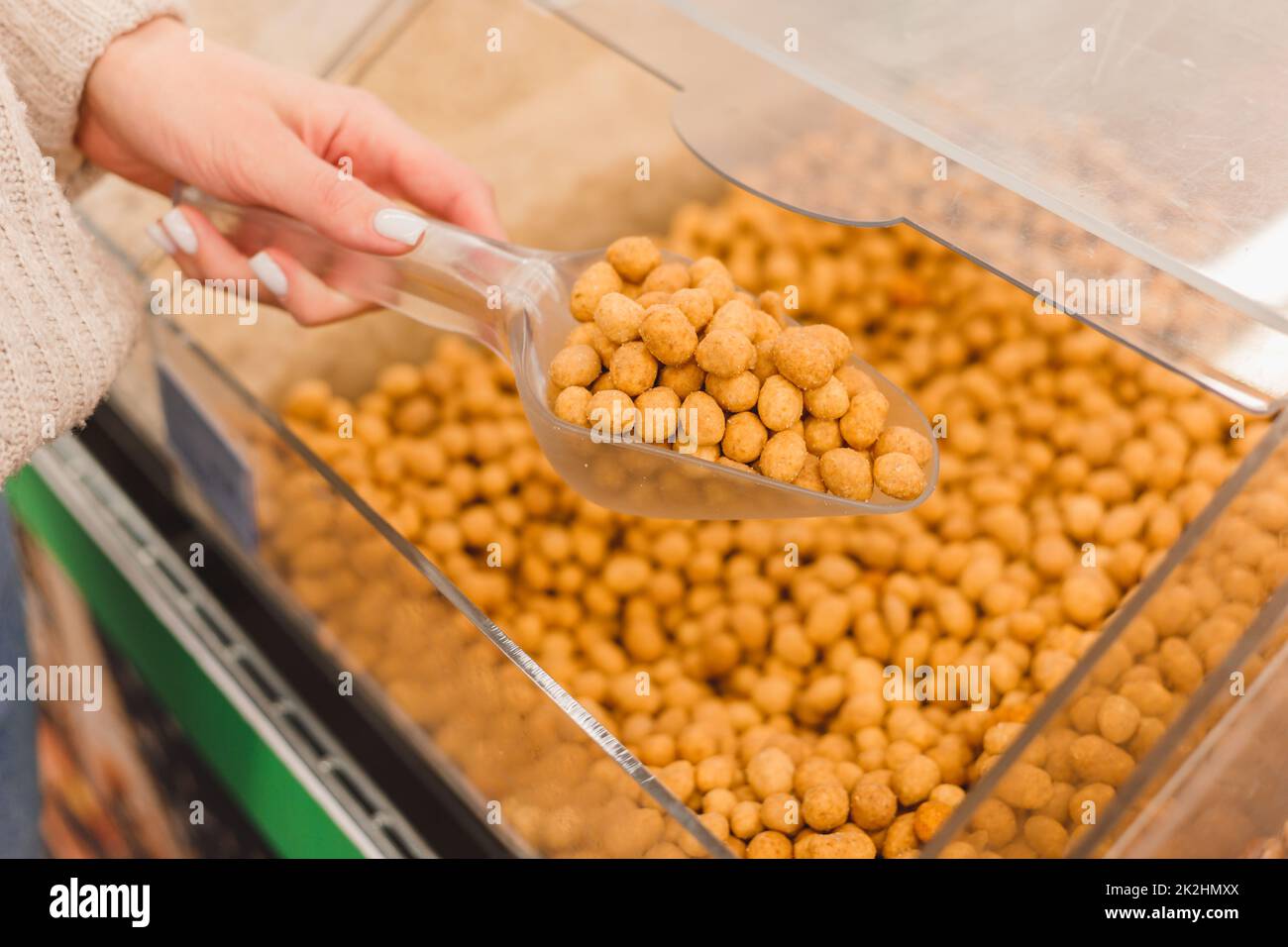 Peanuts in crispy crust with processed cheese flavor, customer's hand ...