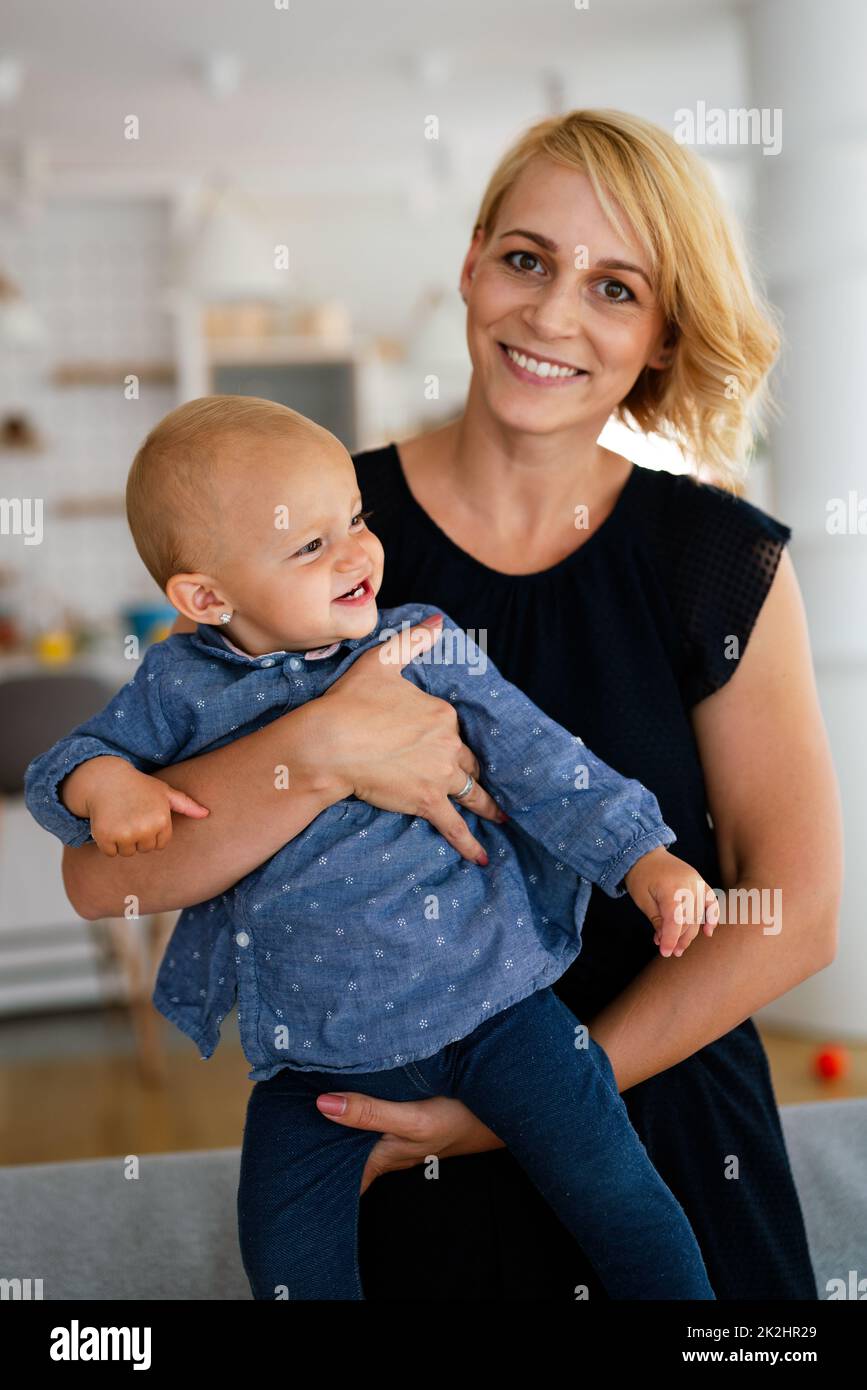 Happy family indoors. Portrait of beautiful mother with cute baby playing smiling together Stock ...