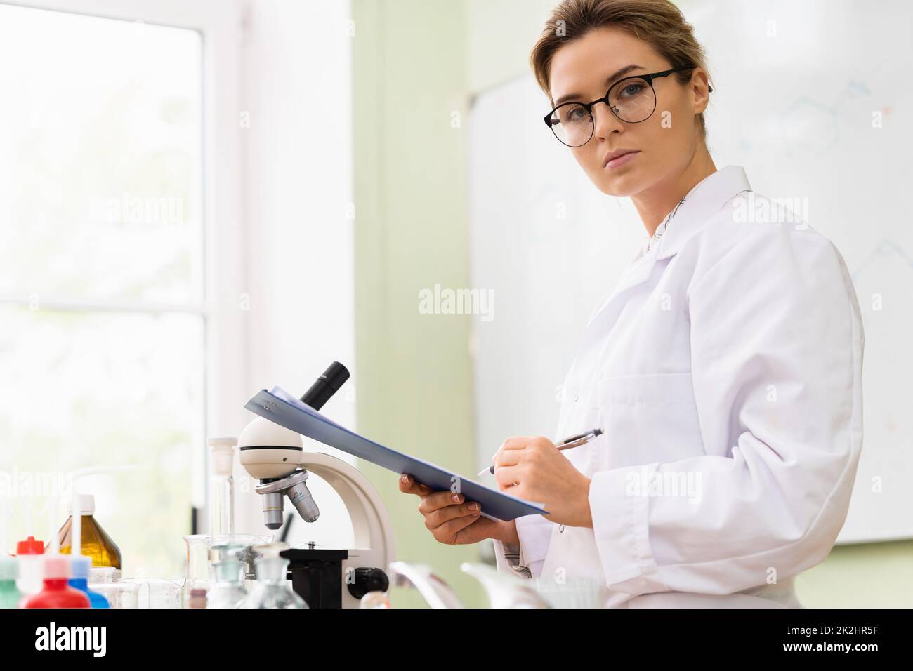 Woman scientist writing a report in a laboratory during research Stock ...
