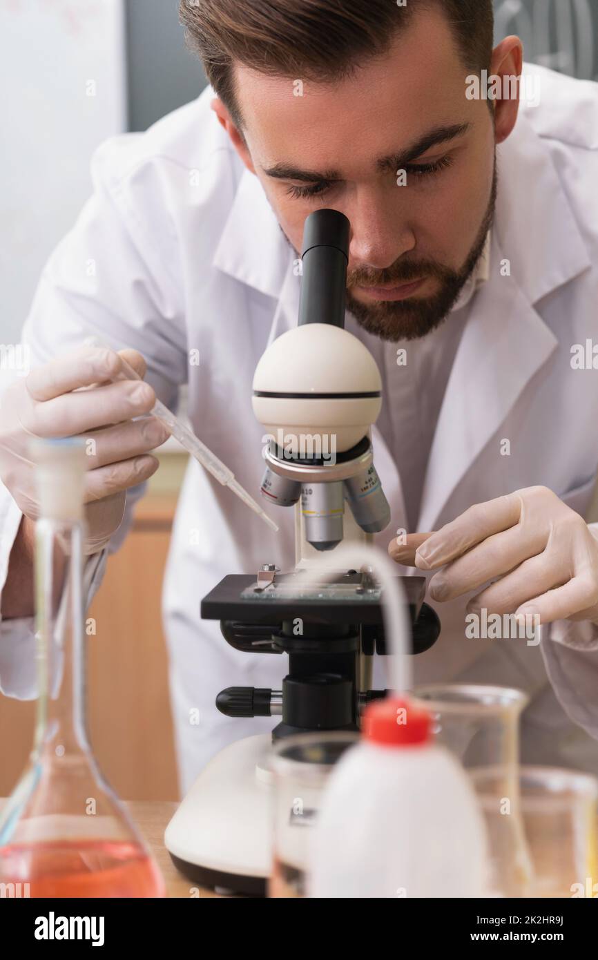 Scientist is using microscope in a laboratory during research Stock ...