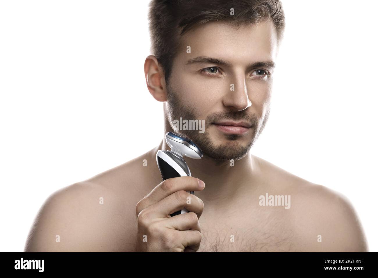Handsome man is using electric shaver on white background Stock Photo ...