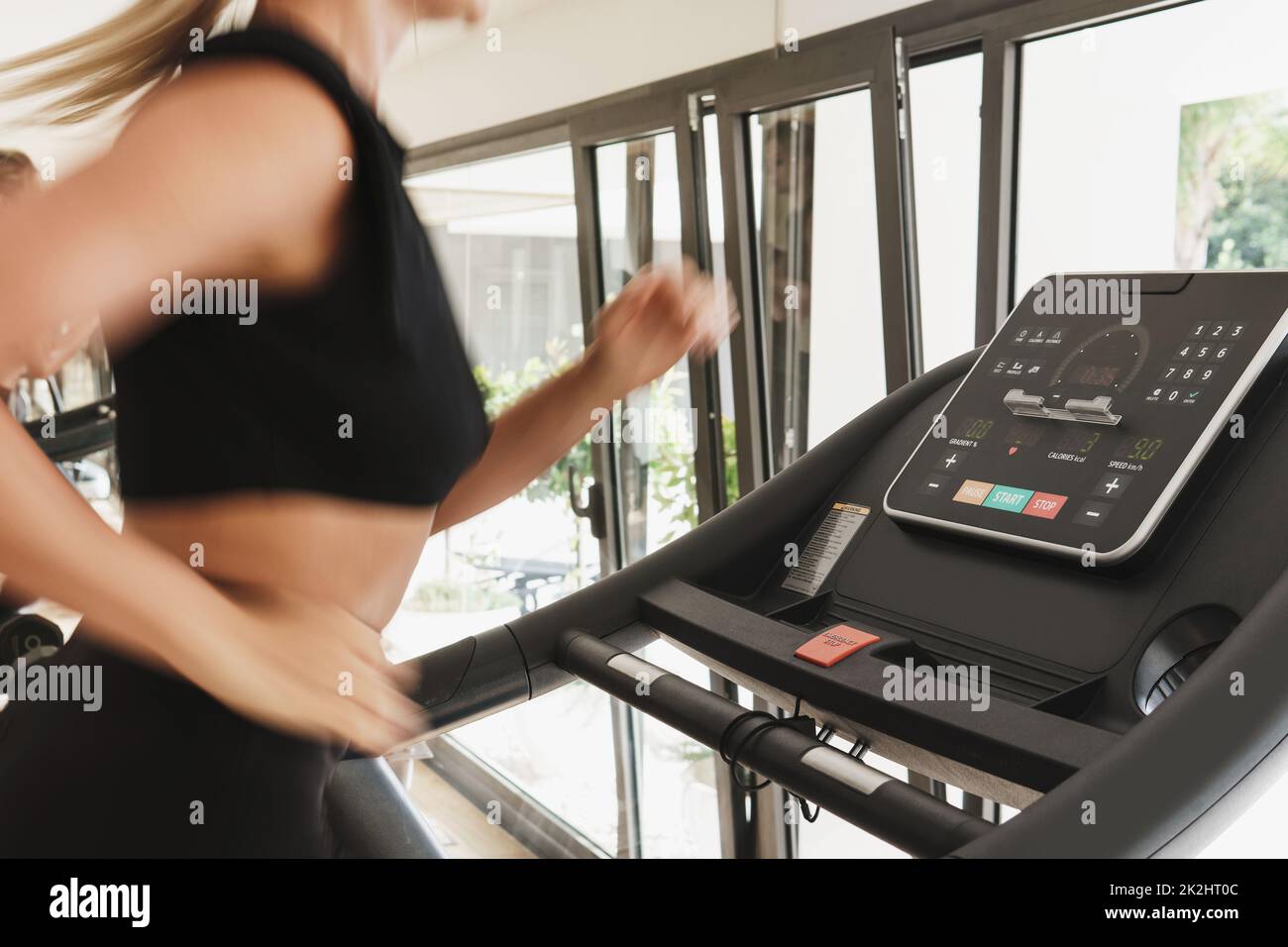 Athletic woman running on treadmill during fitness workout Stock Photo ...