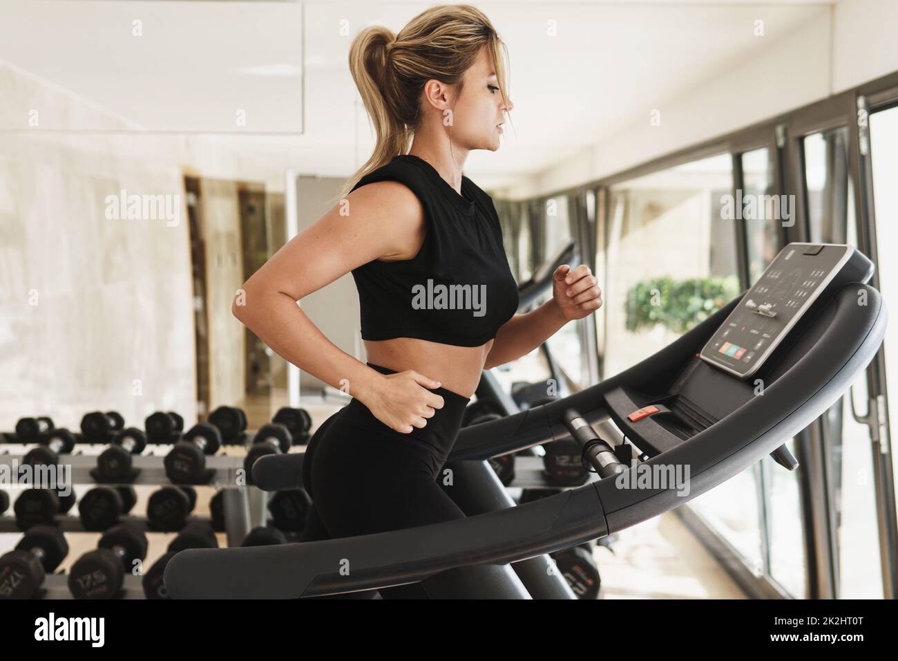 Athletic woman running on treadmill during fitness workout Stock Photo ...