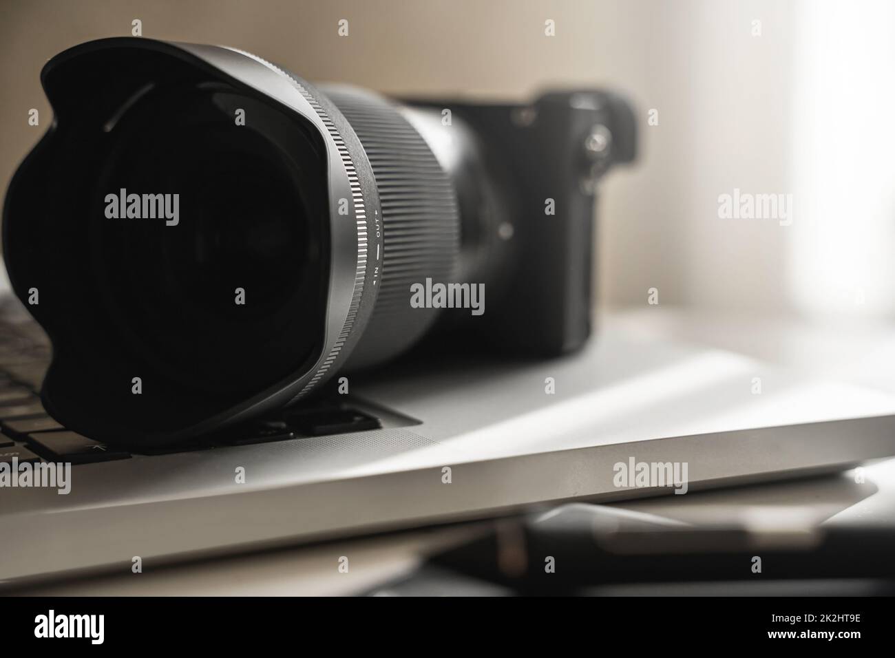 Photographer's workplace with a mirrorless camera, laptop and graphics ...