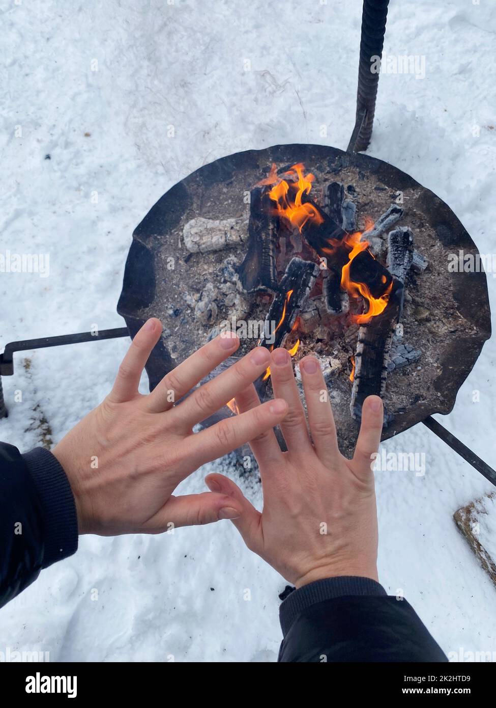 Woman warming up her hands by the fire pit Stock Photo - Alamy