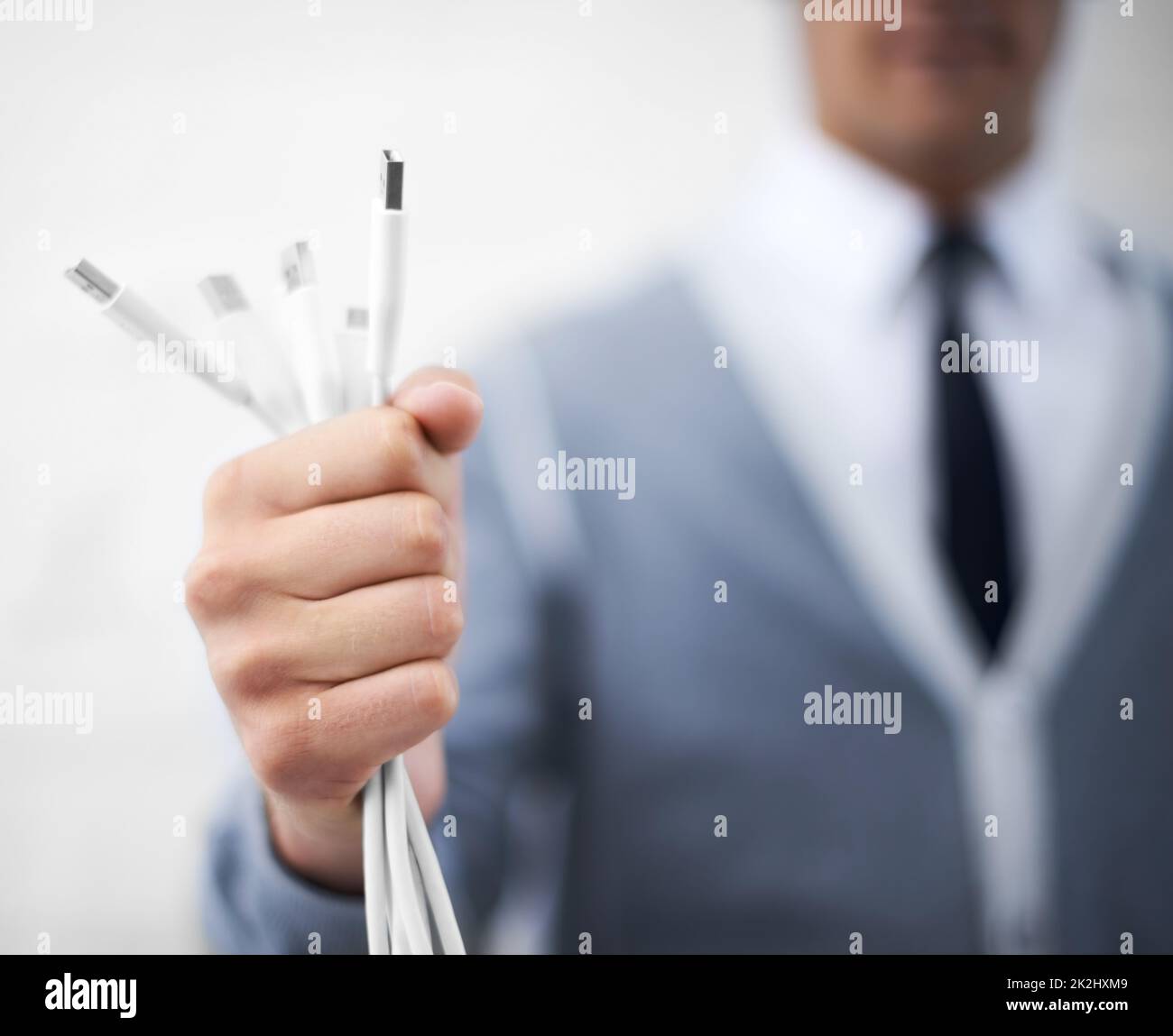 Ready to get wired up. A young nerdy guy holding usb cables toward the ...