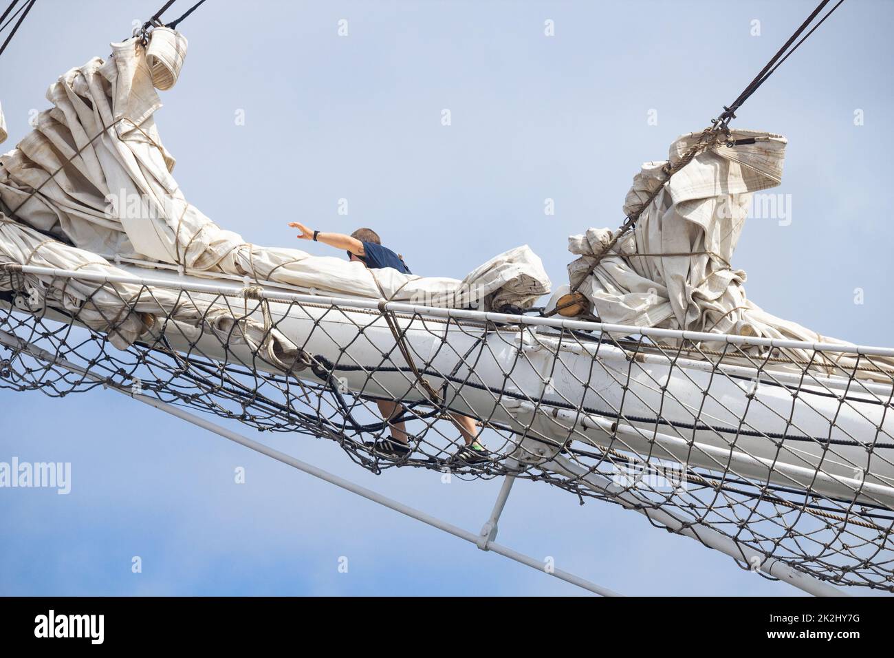 Sailorwalking on safety netting on bow of tall ship Stock Photo - Alamy
