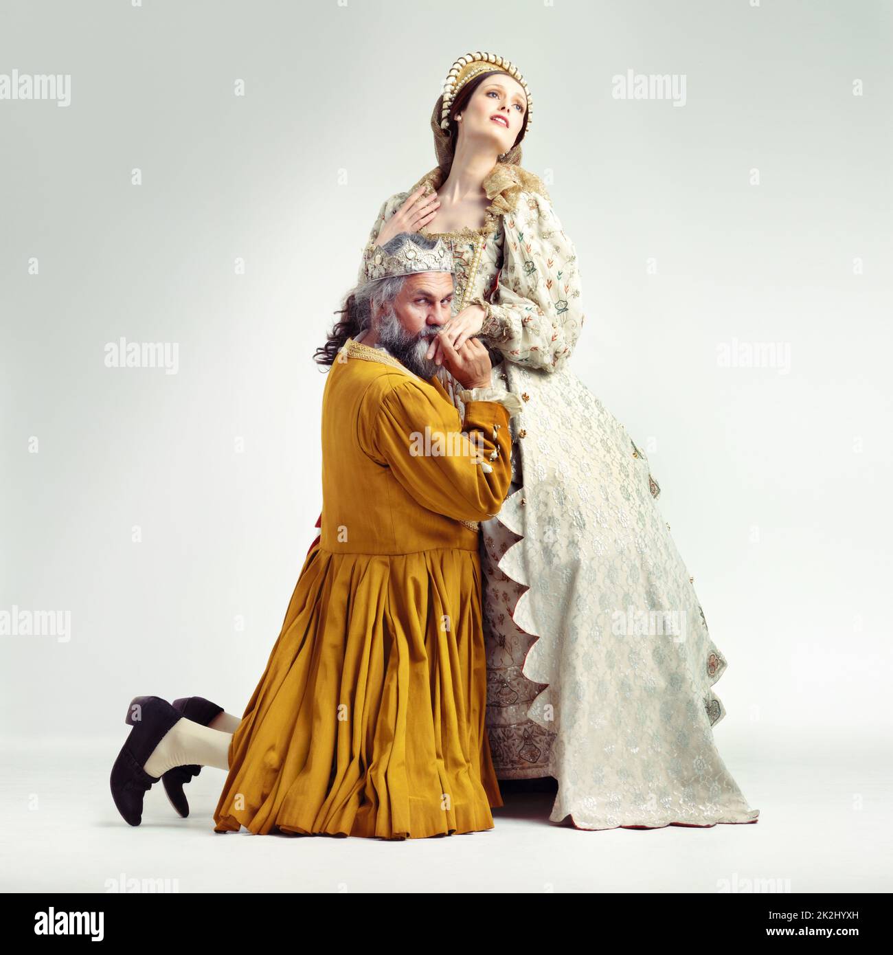 Shes the true power behind the throne. Studio shot of a king kneeling ...