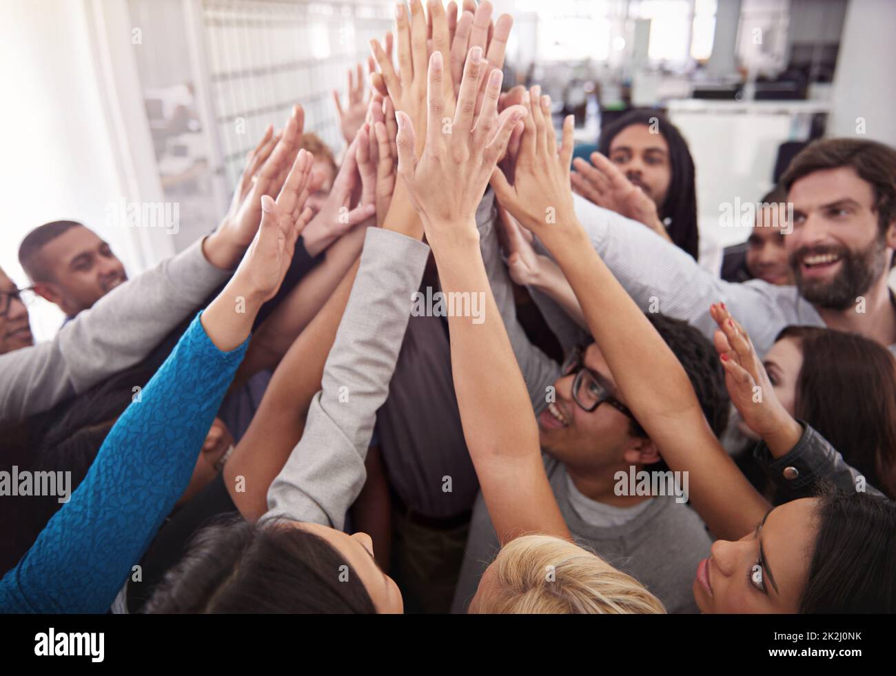 Way to go, team. Shot of a business team raising their hands while standing in a huddle Stock ...