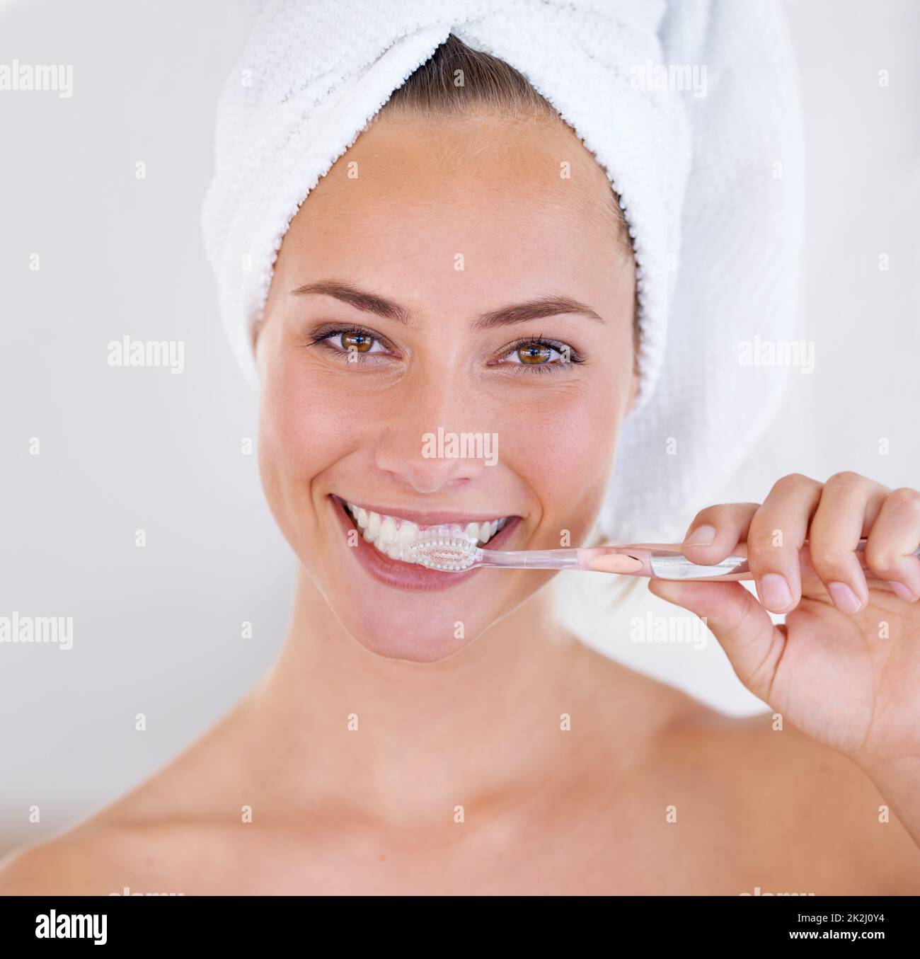 Keeping her smile shining bright. Close up of a pretty lady brushing ...