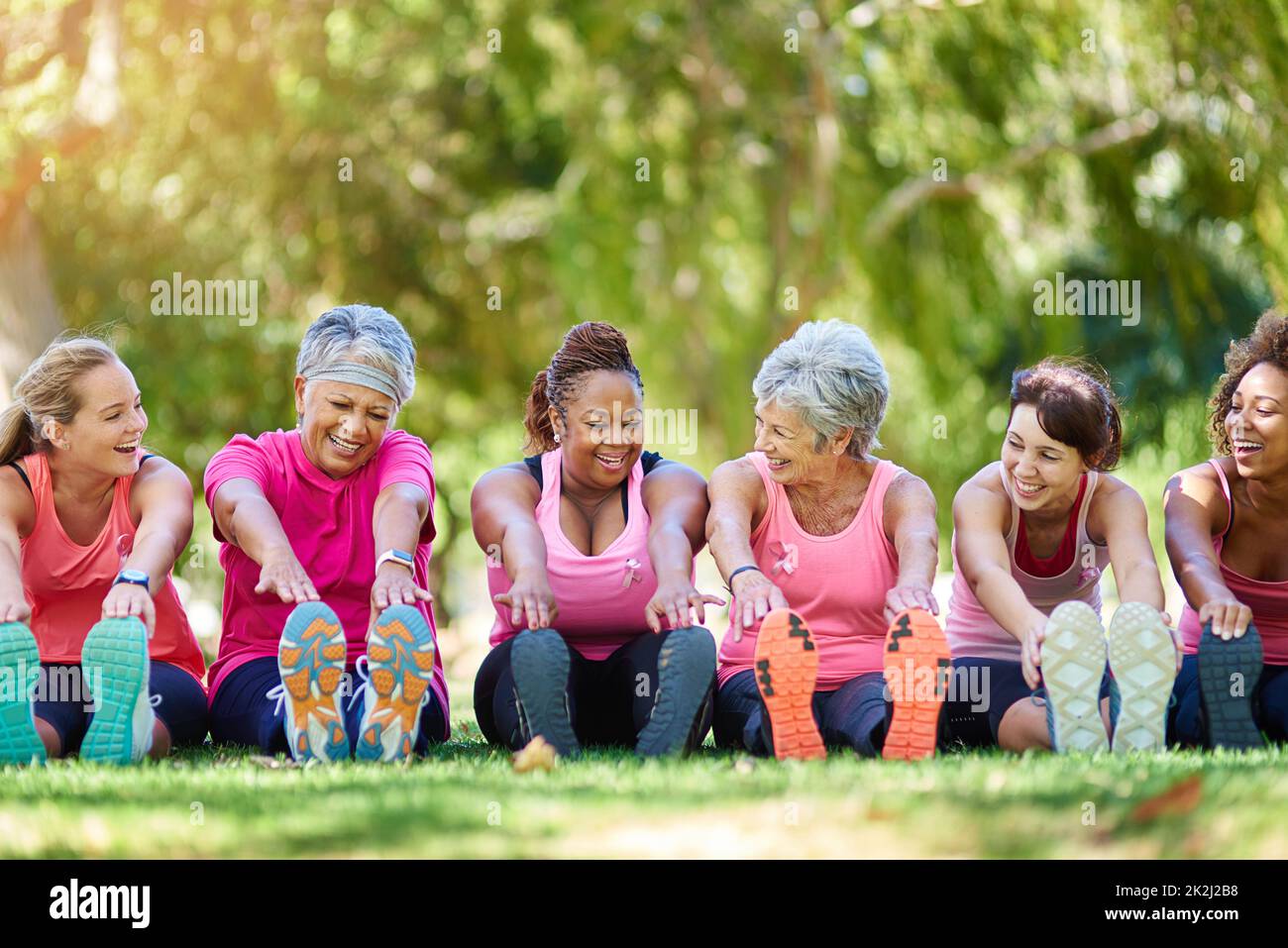 Limbering up before exercise. Shot of a group of people warming up ...