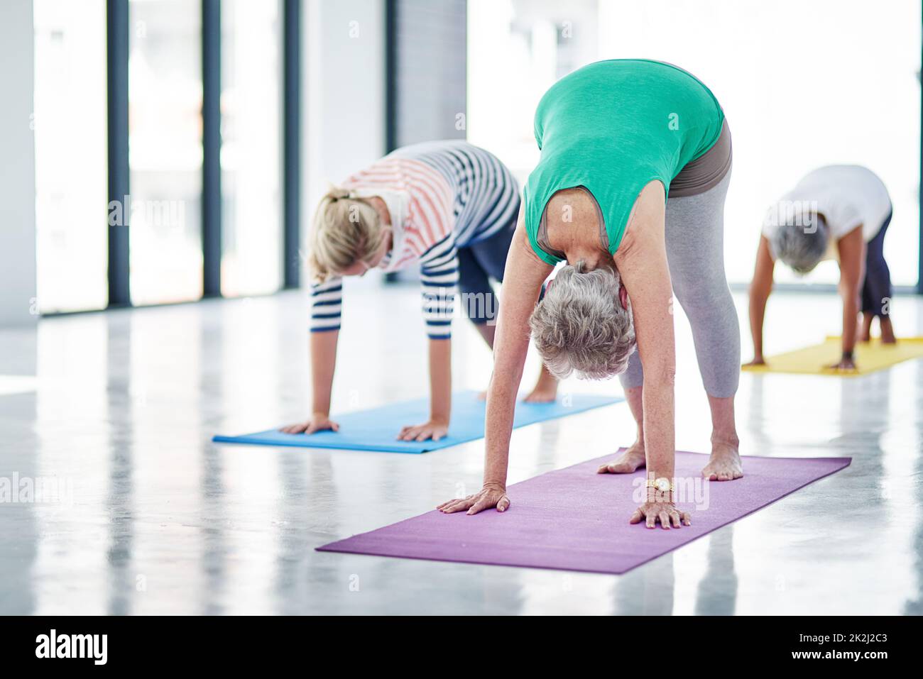 Perfect form. Shot of a group of women doing yoga indoors Stock Photo ...