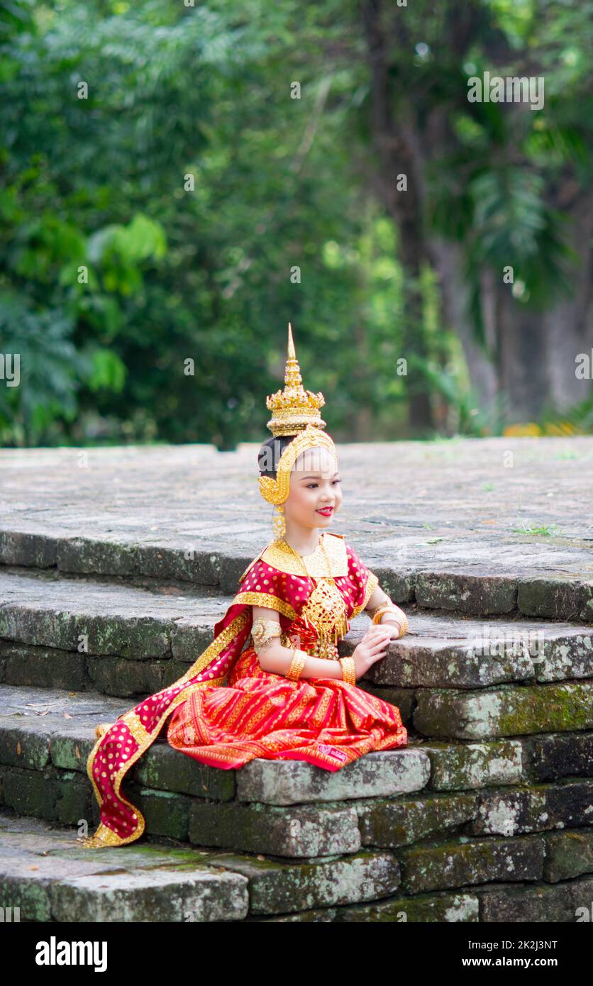 Asian young girl wearing typical, traditional Thai Dress. Red and gold ...