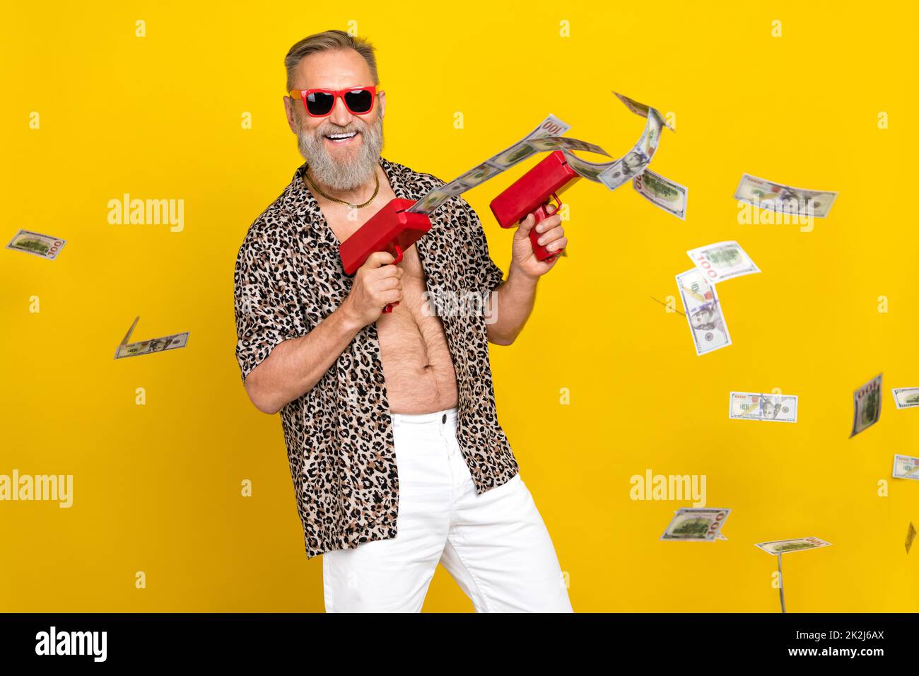 Portrait of excited positive grandfather hold money gun shoot banknotes ...