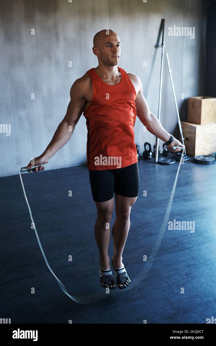 Training to become fighting fit. Shot of a man training with a skipping ...