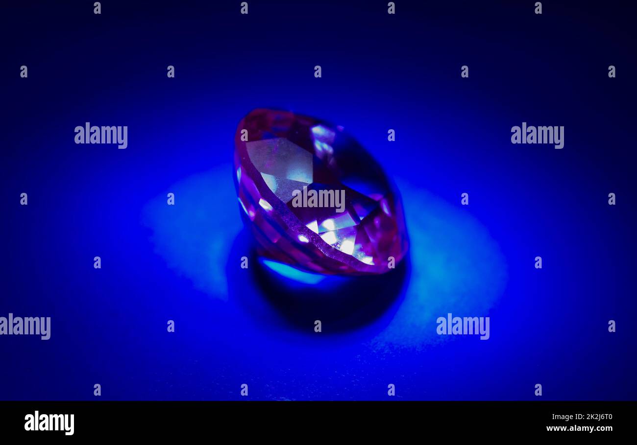 Pink sapphire on a blue background in light Stock Photo - Alamy