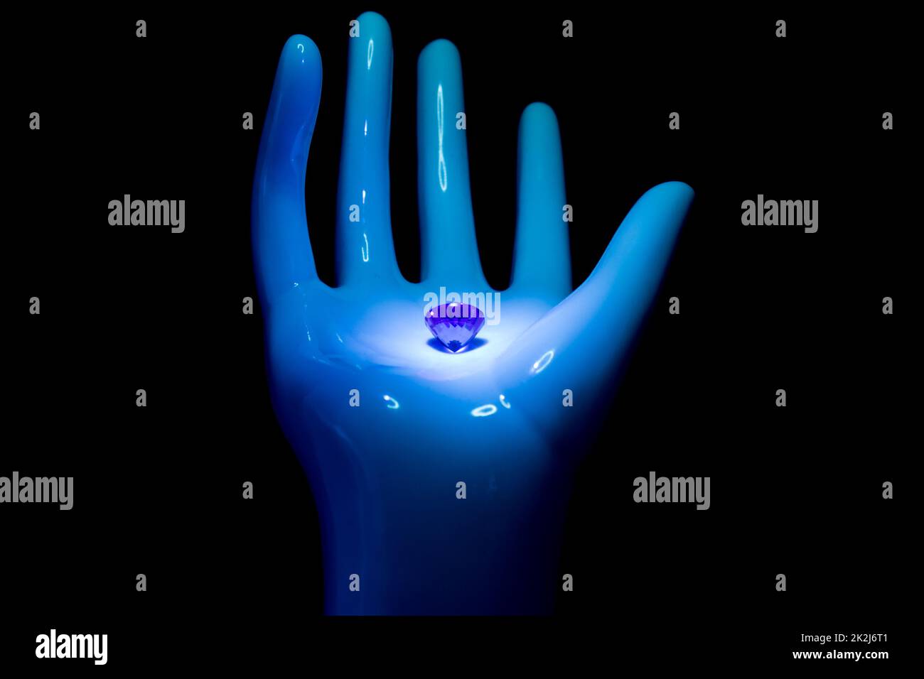 Diamond jewel in the palm of a hand on black background Stock Photo - Alamy