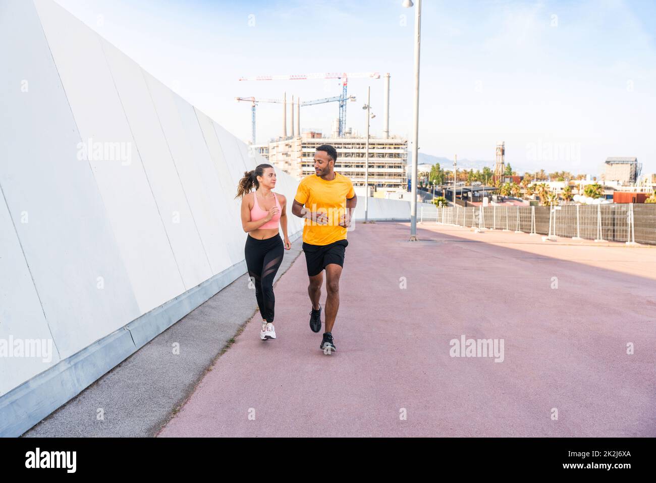 Interracial sportive couple running outdoors - Multiracial couple of ...
